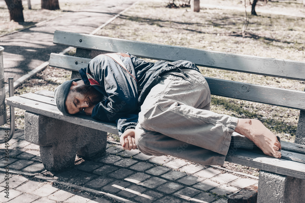 Poor homeless man lying on bench outdoors Stock Photo | Adobe Stock