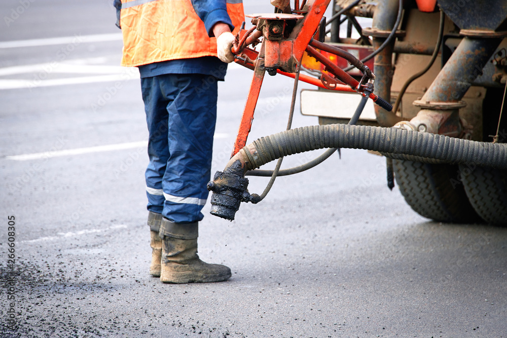 Professional worker in uniform during fast repair road surface ...