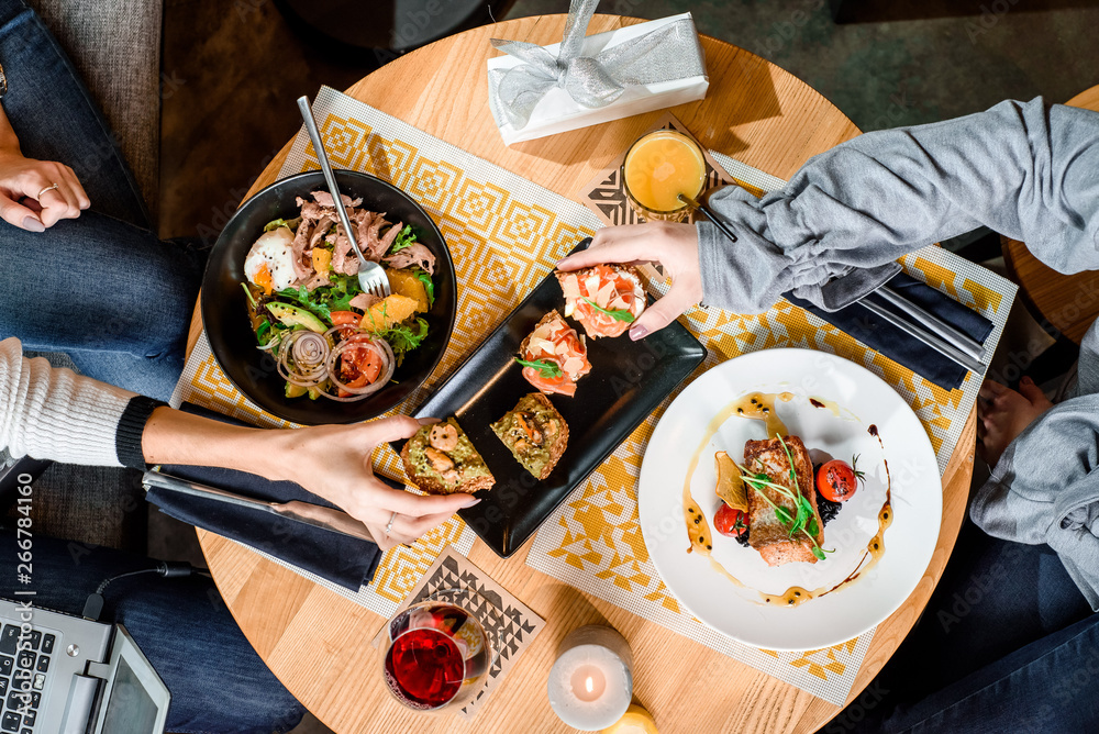 Brunch friends. Girls eat risotto and salads, the guy works behind a ...