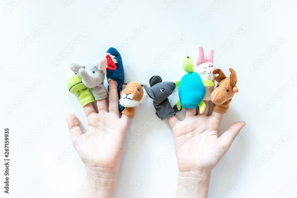 Hands of a child with finger puppets, toys, dolls close up on white ...