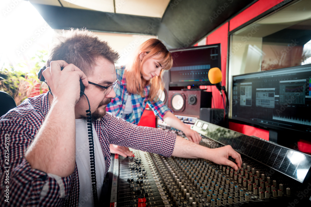 Music engineer and musician working together in recording studio using ...