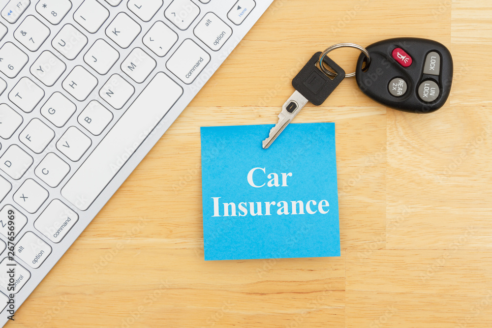 Car insurance message with car keys with a keyboard on a sticky note ...