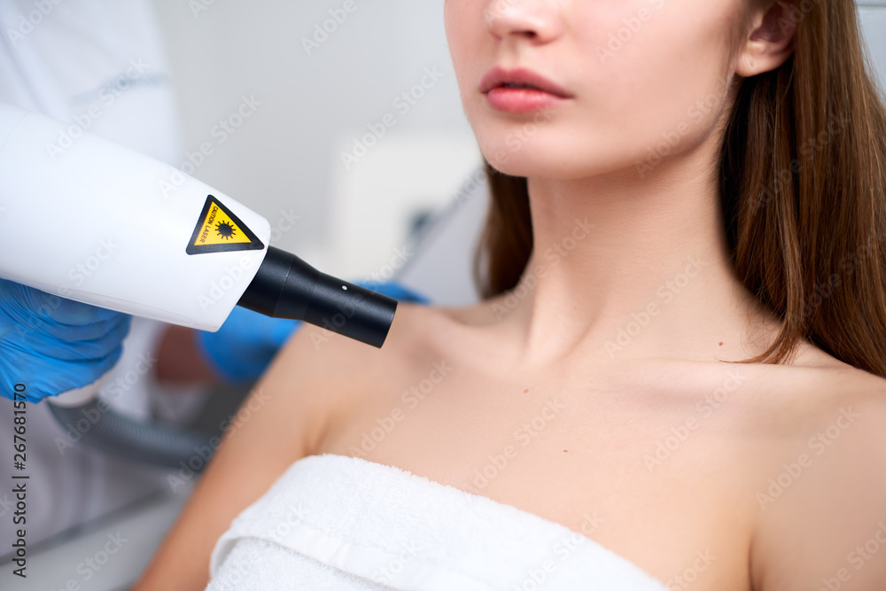 Laser mole removal on a woman's chest in a beauty salon. Hardware ...
