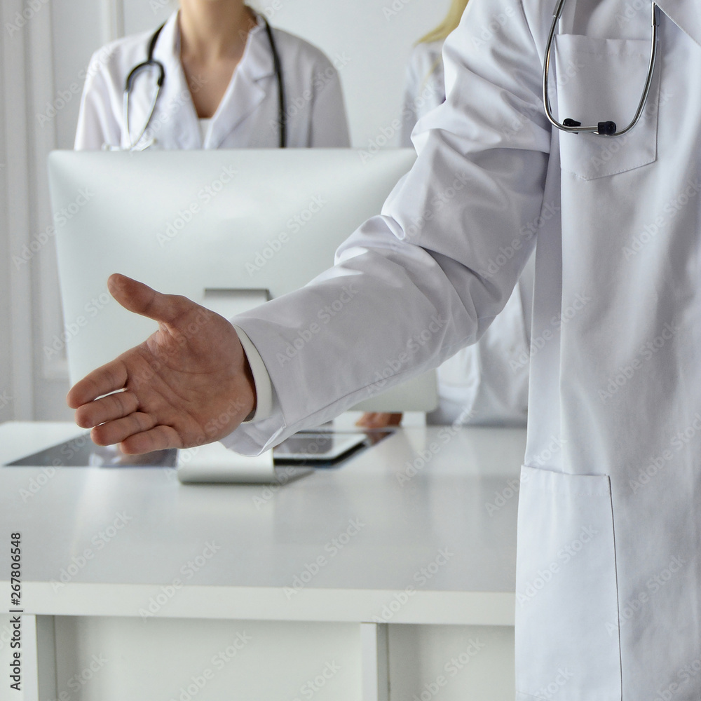 Welcoming. Doctor greets a patient by handshake. Male practitioner with ...