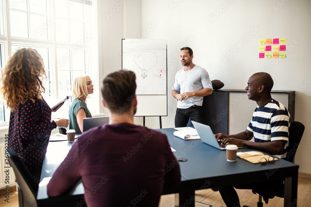 Smiling manager talking to staff during a whiteboard presentatio Stock ...