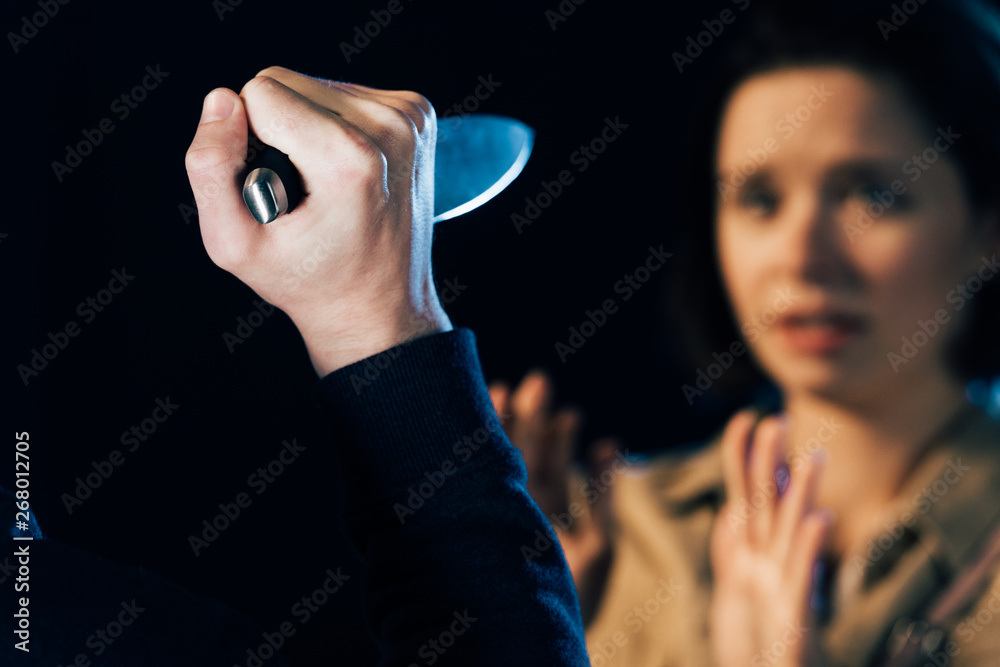 partial view of criminal attacking woman with knife isolated on black ...