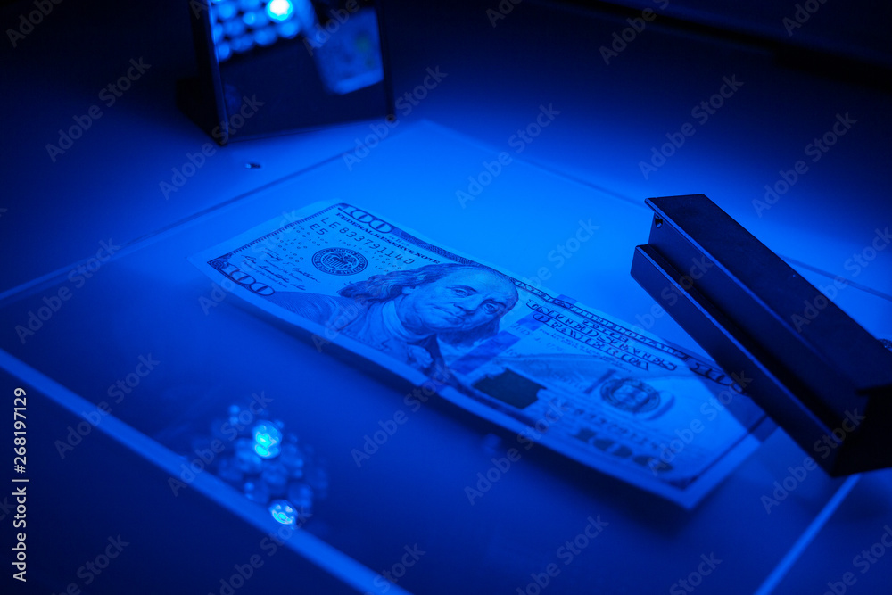 Verifying the authenticity of the hundred dollar bill in azure light ...