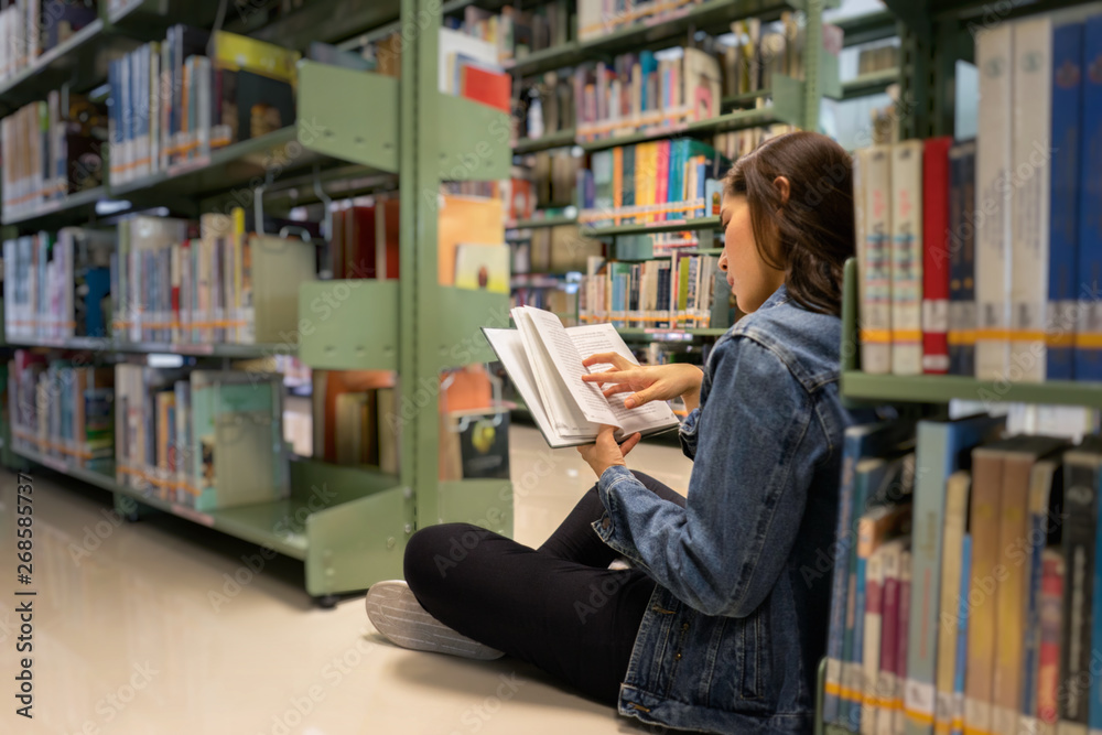 Asian female student sitting on floor in the library, Open and learning ...