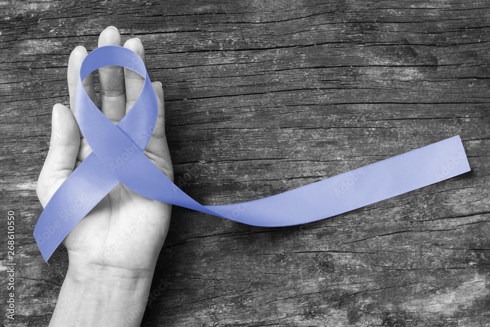 Periwinkle blue ribbon awareness with color bow on hand support for ...
