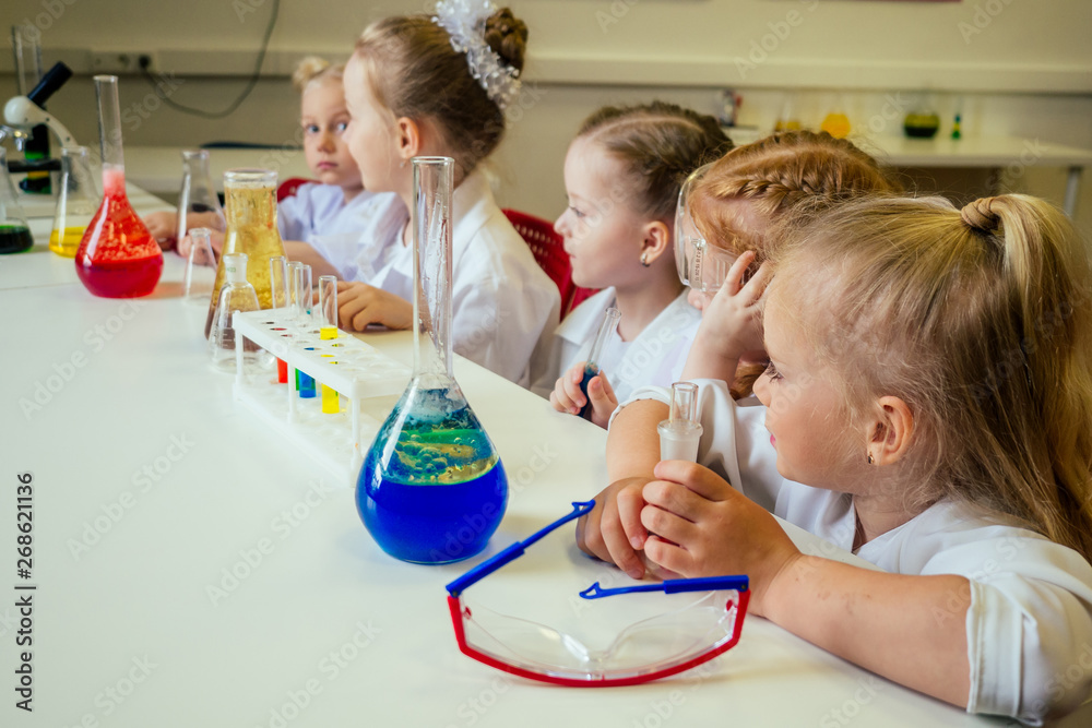 group of school girl kids with teacher in school laboratory making ...