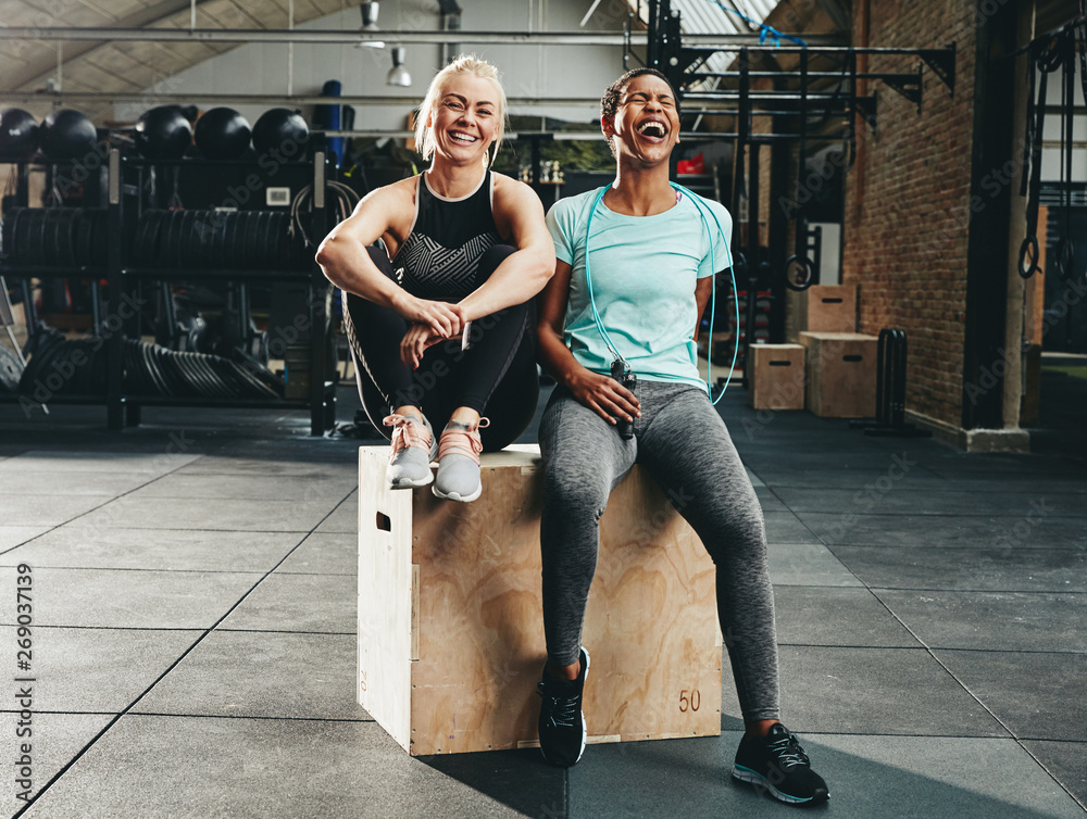 Two young women laughing after working out at the gym Stock Photo ...
