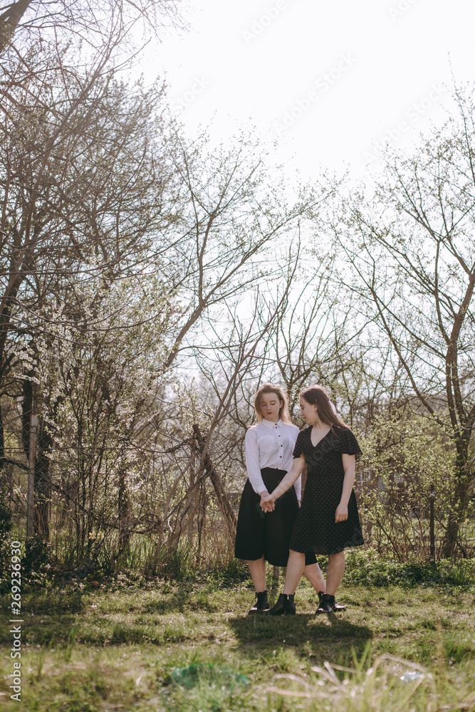 Portrait of two beautiful young sisters in the green spring garden ...
