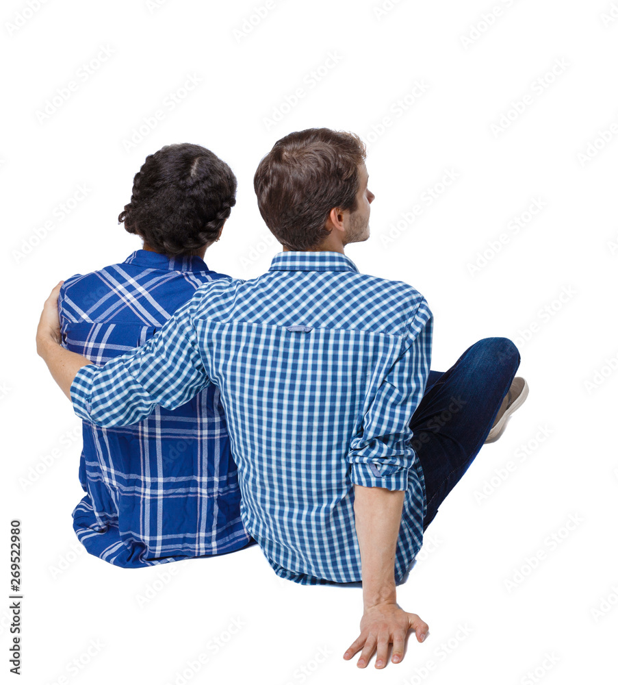 Back view of a multiethnic young couple sitting on the ground and ...