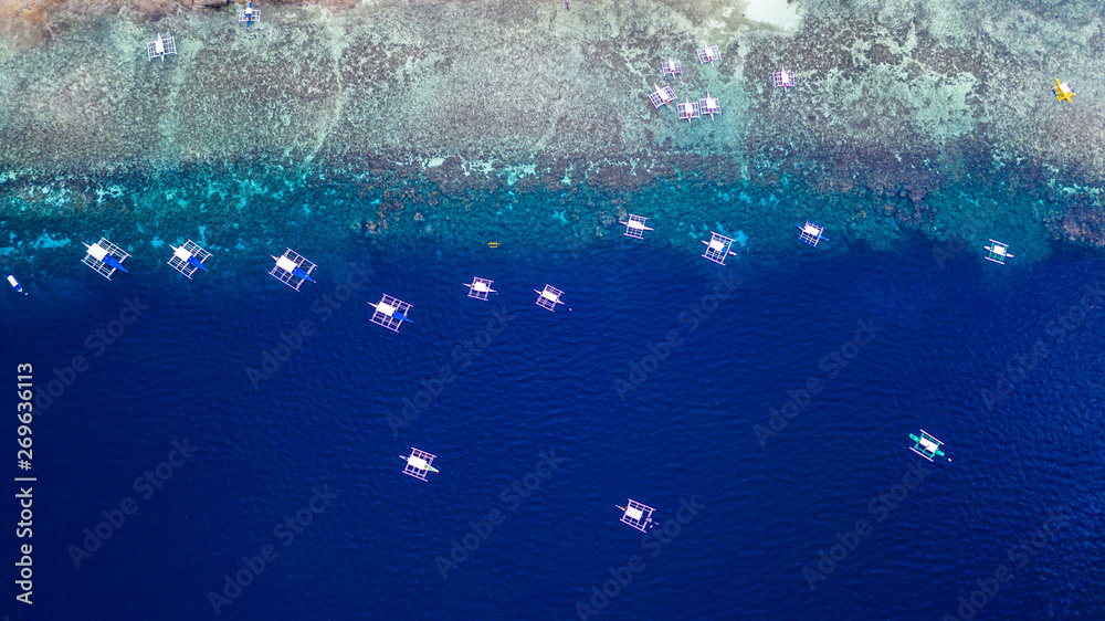 Aerial view of Filipino boats floating on top of clear blue waters ...