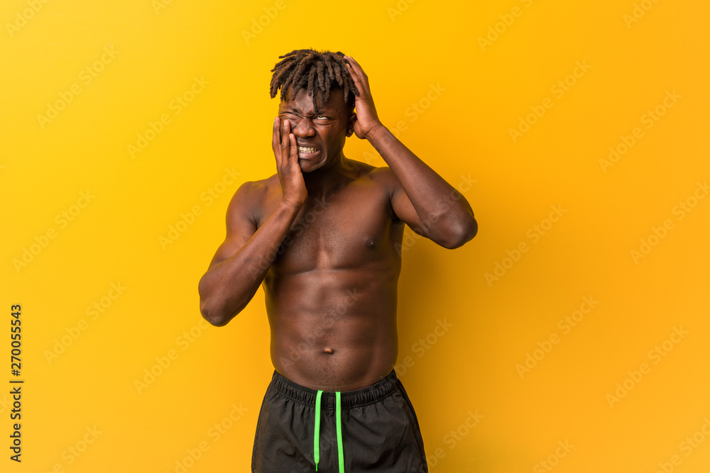 Young black man shirtless wearing swimsuit whining and crying ...