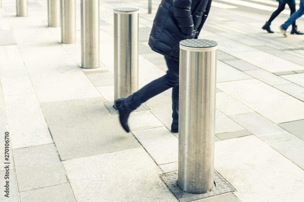 Man walking by stainless steel bollard entering pedestrian area on ...