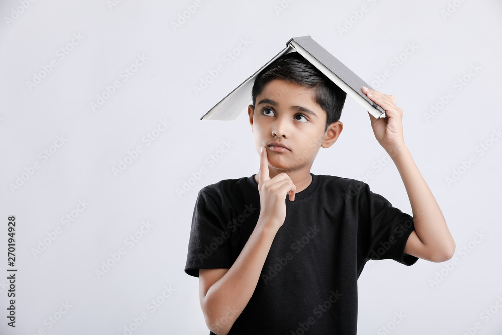 little Indian / Asian boy with book on head and thinking seriously ...