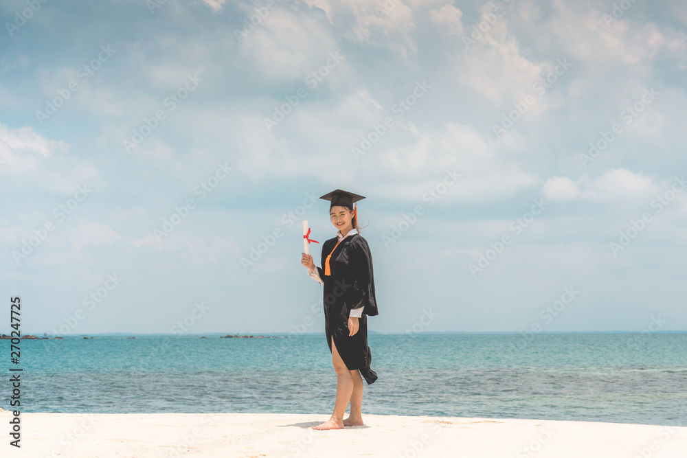 Graduated woman in cap and gown holding certificated celebrating in ...