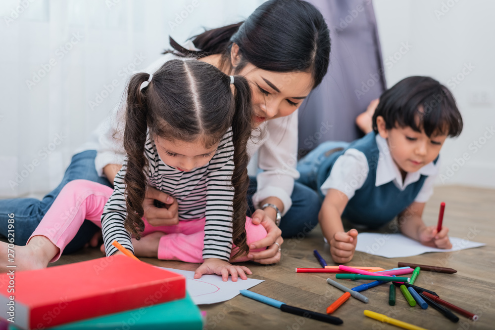 Mother teaching children in drawing class. Daughter and son painting ...