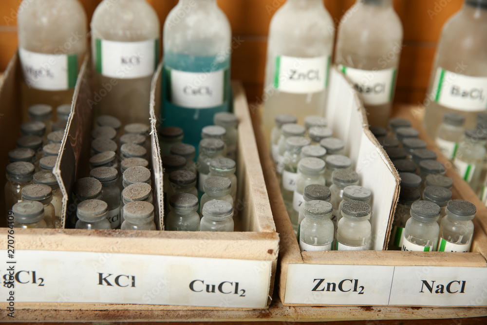bottles with solutions of KCl, CuCl2, ZnCl2, NaCl on the shelf of the ...