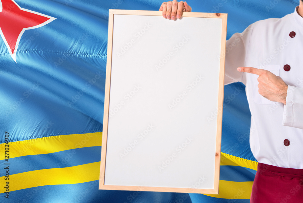 Chef holding blank whiteboard menu on Aruba flag background. Cook ...