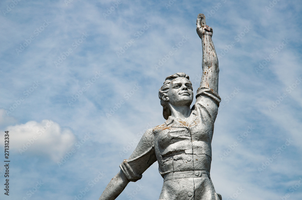 Closeup of old dilapidated stone statue of Soviet woman on sky ...