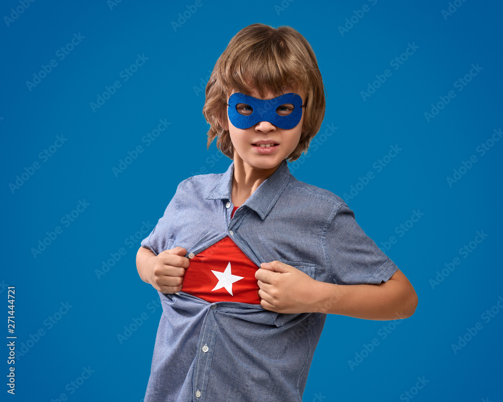 Confident boy showing superhero emblem Stock Photo | Adobe Stock