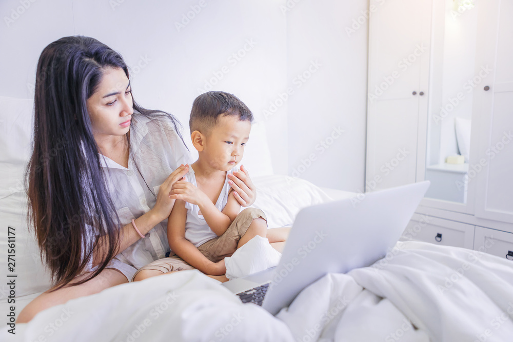 Mother take care her boy because of overuse the laptop computer in the ...