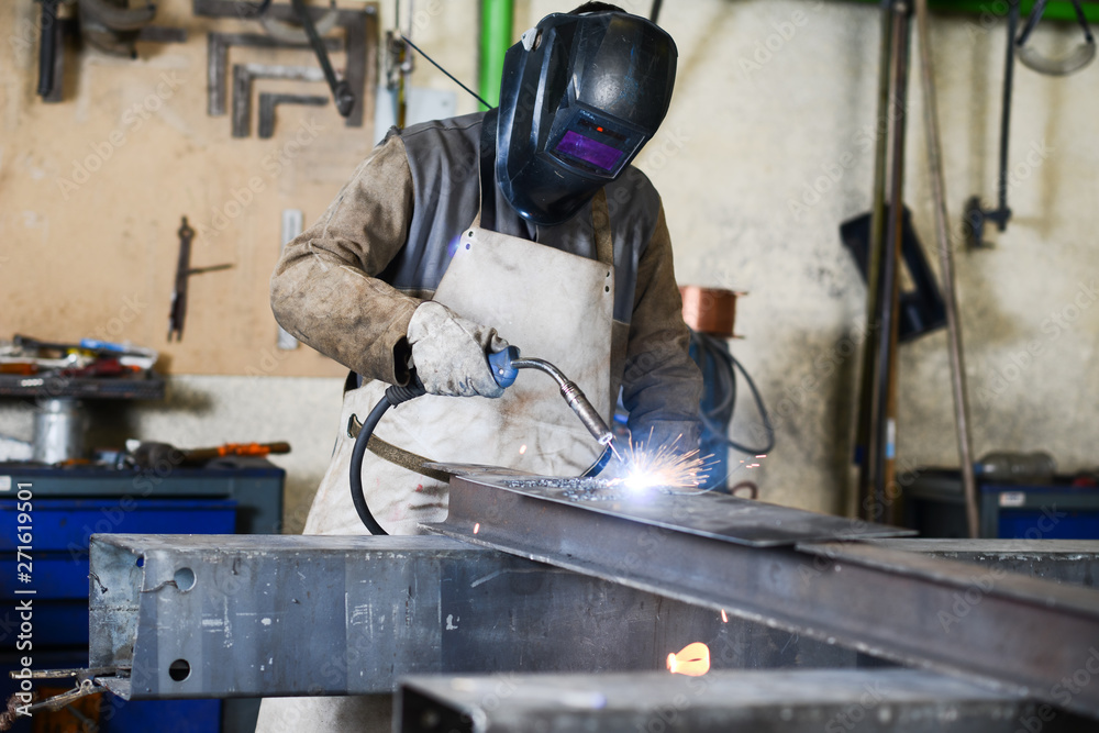 handsome man workshop welding iron spark fire hot steel with power GMAW ...