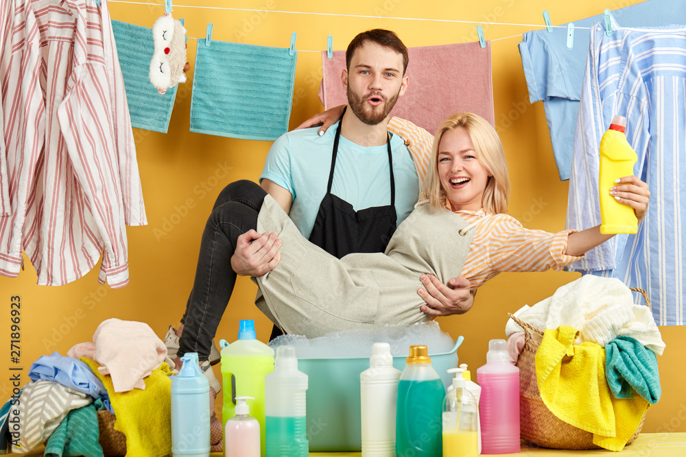 funny young couple having fun while doing household chores. feeling and ...