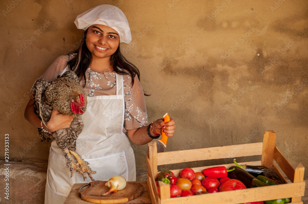 Attractive Indian woman cook posing in kitchen with chicken in her ...
