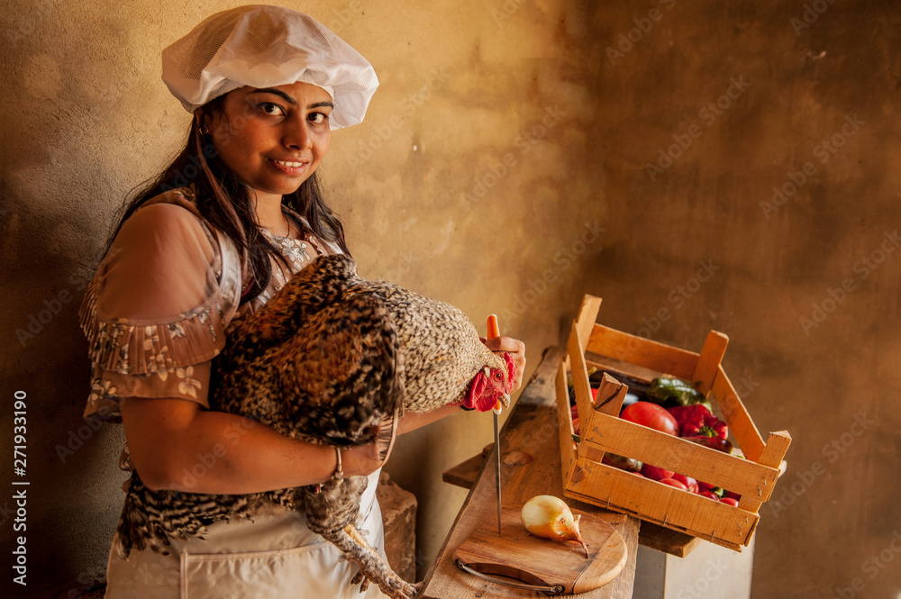 Attractive Indian woman cook posing in kitchen with chicken in her ...