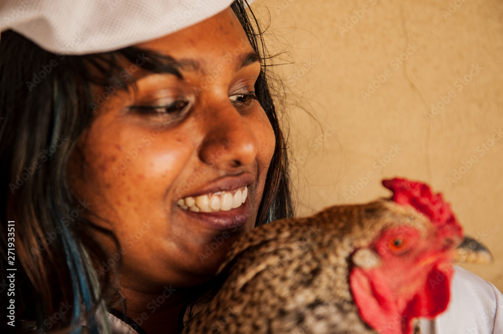 Attractive Indian woman cook posing in kitchen with chicken in her ...