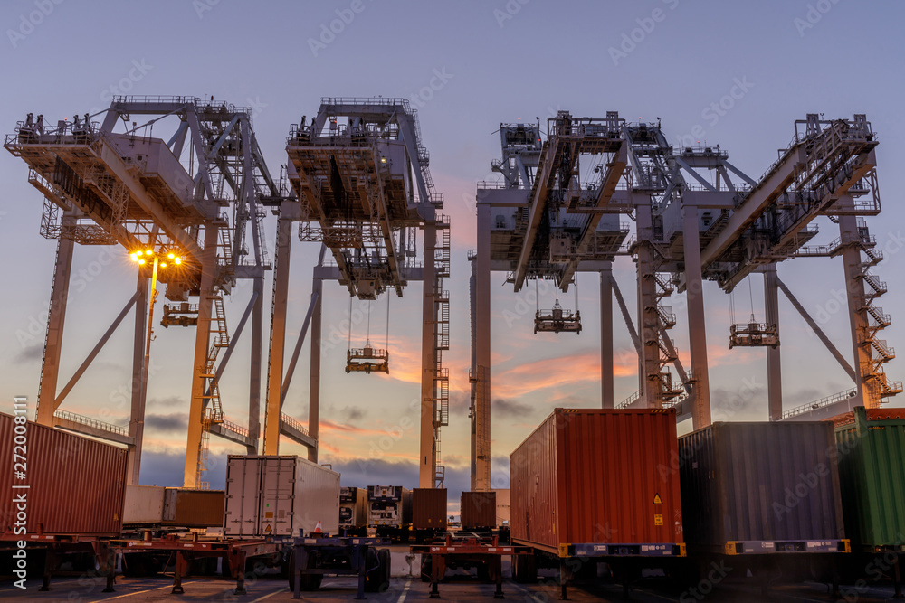 Shipping Container Cranes and Trucks with Sunset Sky in the Port of ...