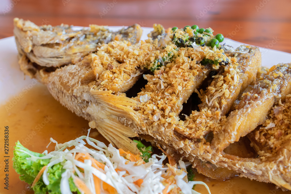 Fried fish with garlic and white cabbage, carrots Stock Photo | Adobe Stock