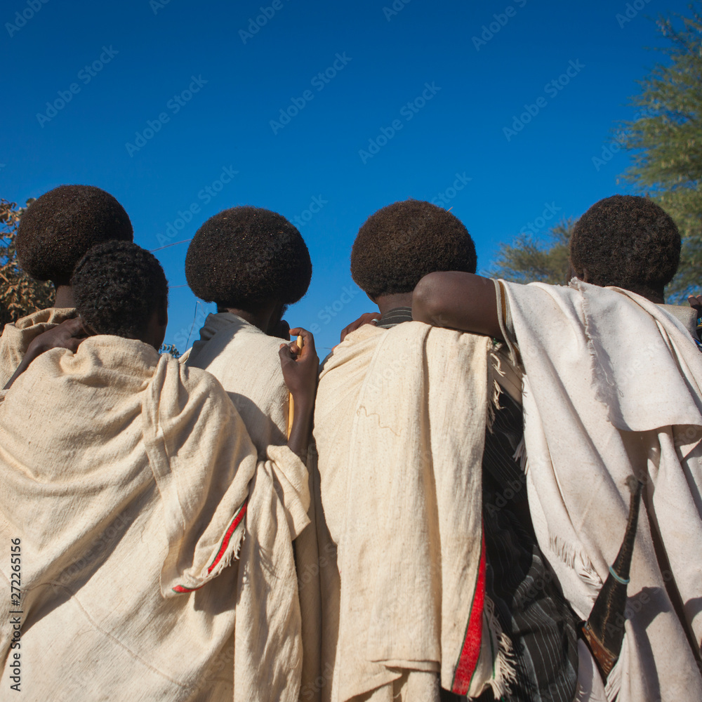Rear view of karrayyu tribe men with gunfura hairstyle during gadaaa ...