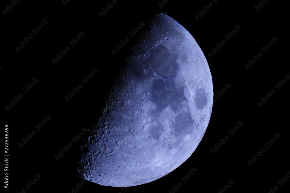 Extreme zoom tele photo of half moon as seen at night on a clear sky ...