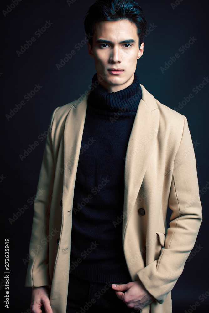 handsome asian fashion looking man posing in studio on black background ...