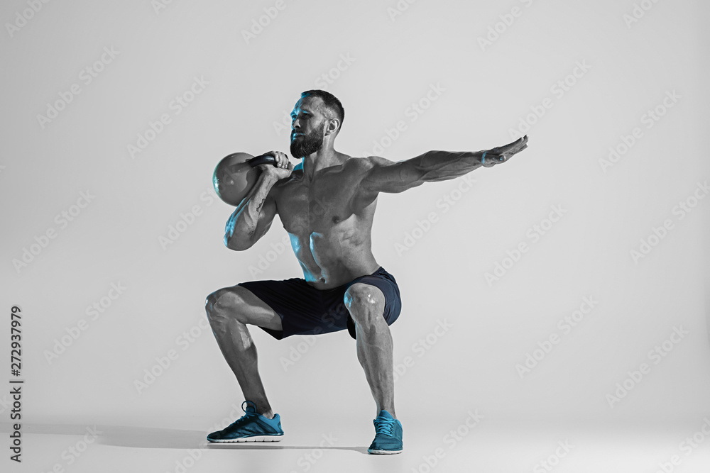Like an iron. Young caucasian bodybuilder training over studio ...