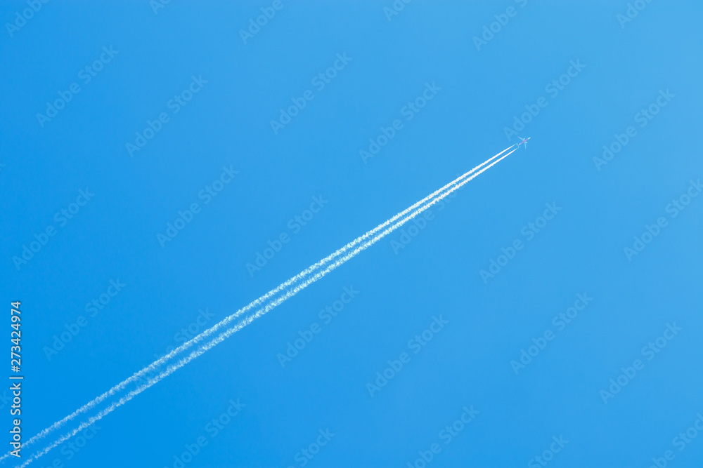 jet airplane flying at high altitude with contrails on beautiful blue ...
