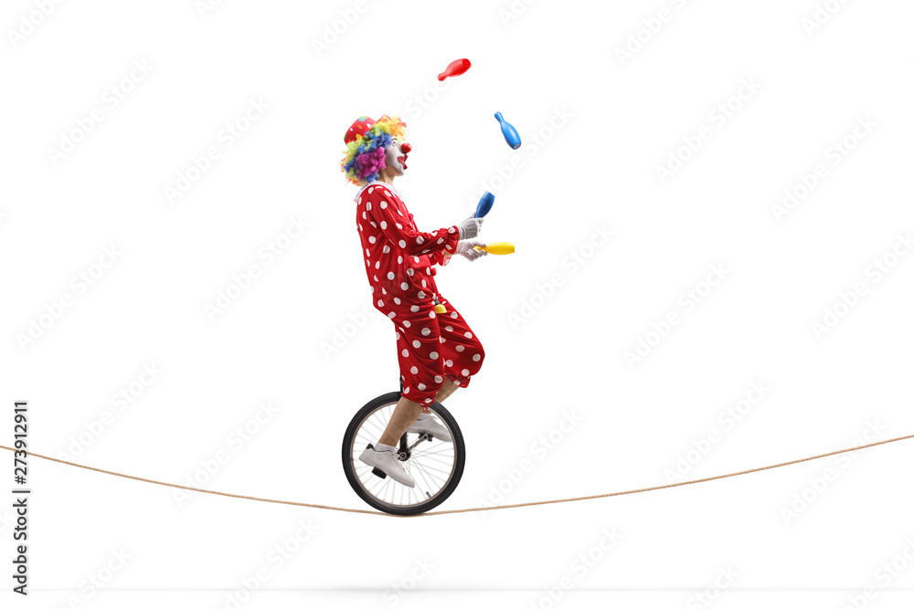 Clown juggling with clubs and riding a unicycle on a rope Stock Photo ...