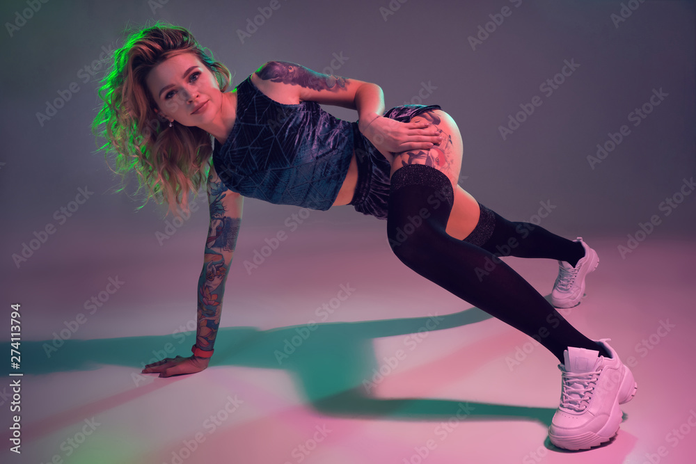 beautiful caucasian blonde girl in velour blue booty shorts and black stockings dancing twerk on ...