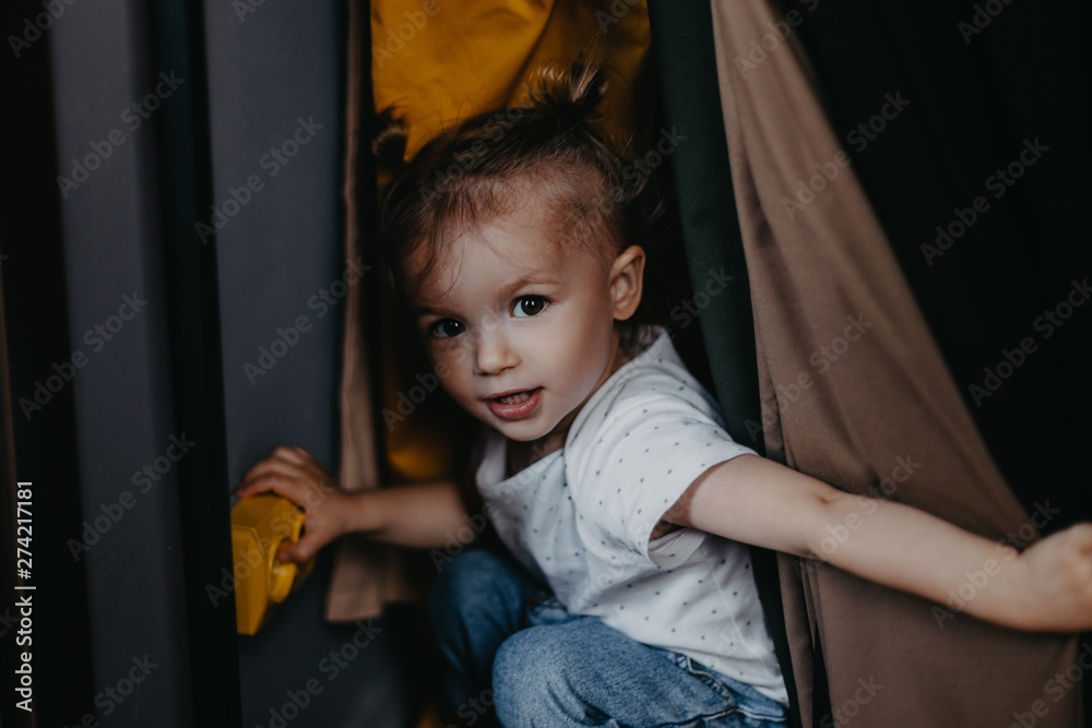 very happy, sincere and smiling girl of 2 years, is playing among ...