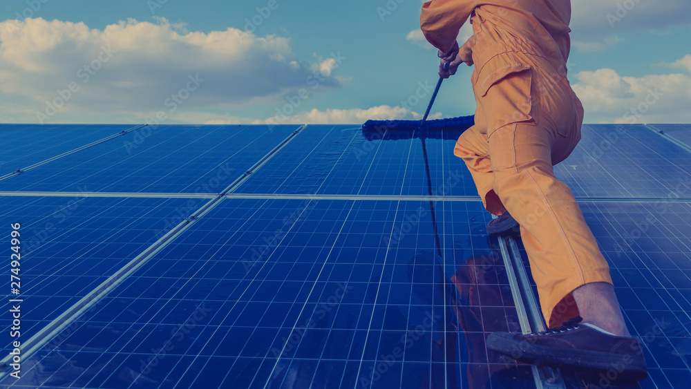 labor working on cleaning solar panel at solar power plant; operation ...