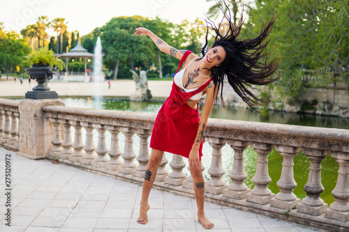 tattooed transgender model is dancing in the green park. Emotional ...