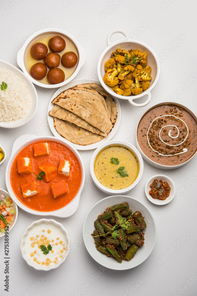 Assorted Indian food like paneer butter masala, dal, roti, rice, sabji ...
