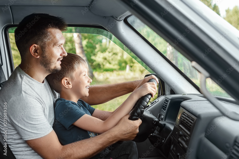 Стокове фото Man, father teaches little son to drive on the road ...