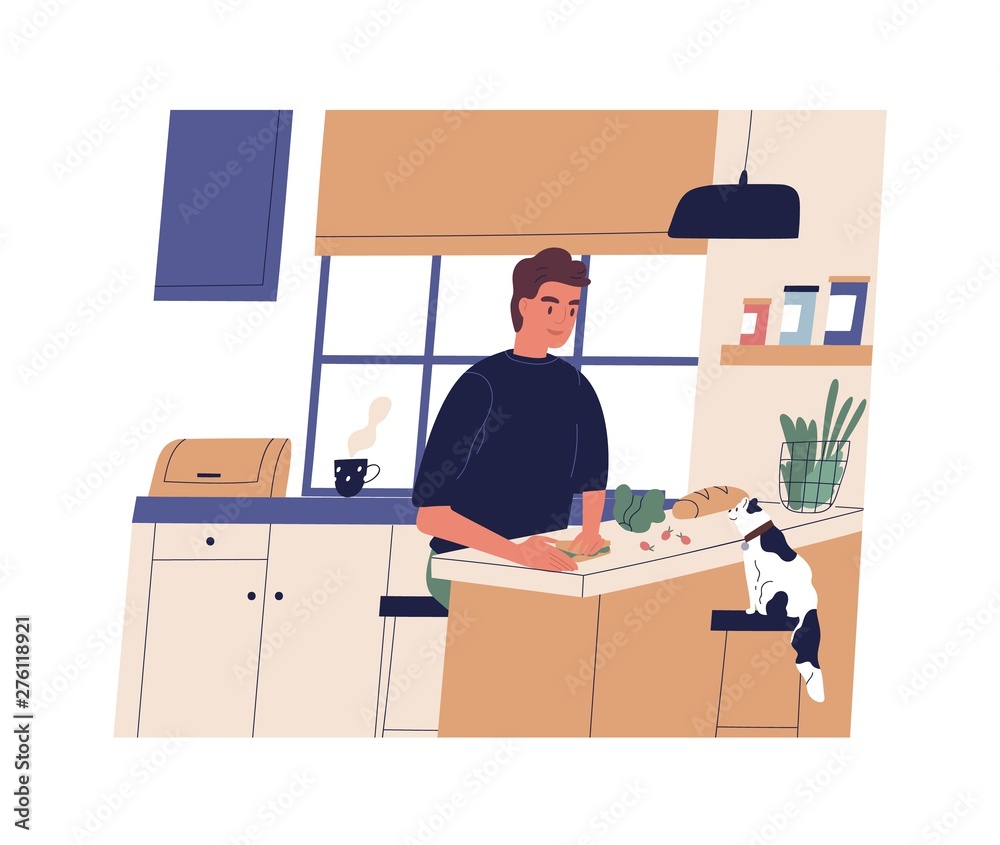 Funny young man making sandwich in kitchen. Happy cute boy cooking at ...