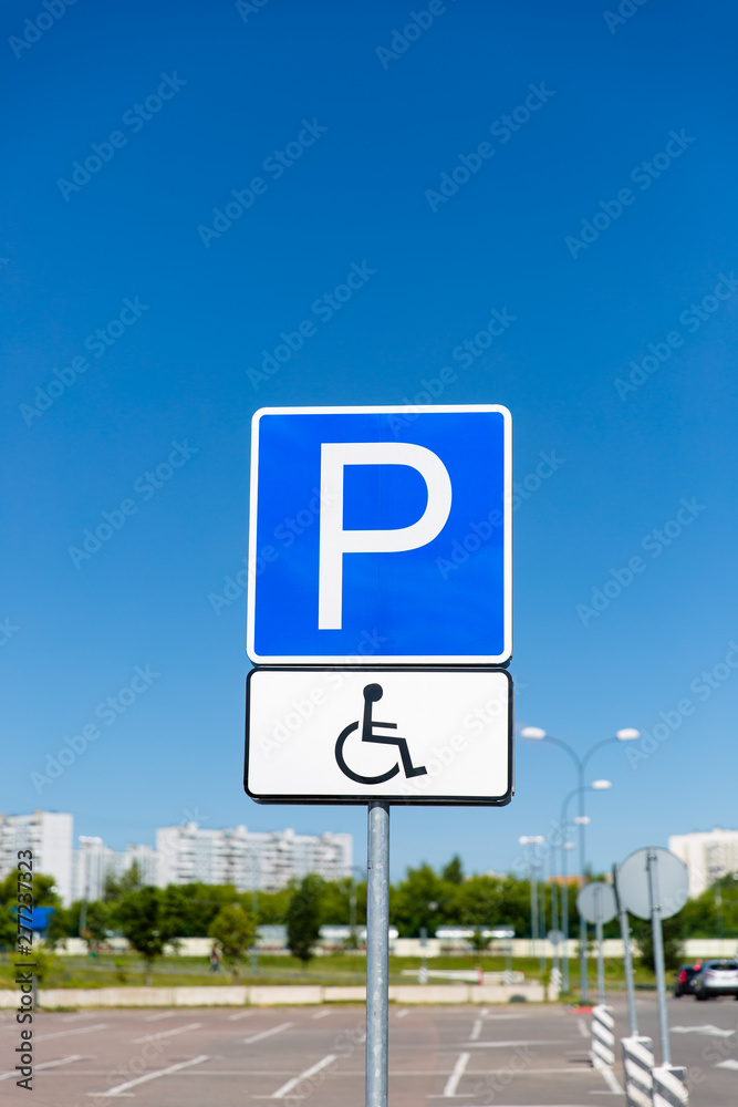 Disabled parking space and wheelchair way sign and symbols on a pole ...