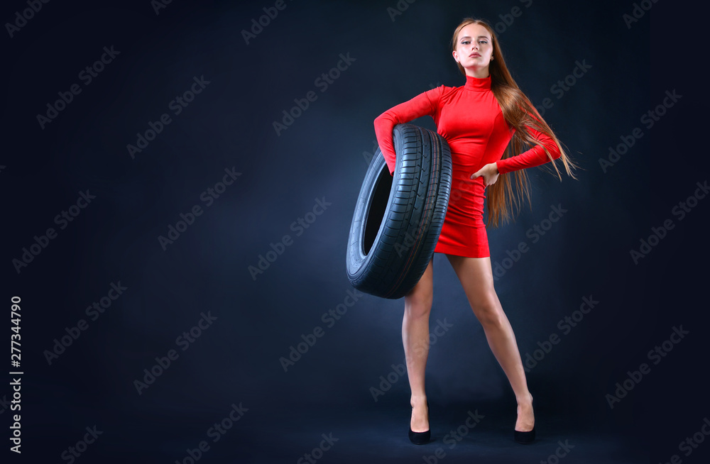 Woman holding tire in her hands. Car tires background. Banner with copy ...